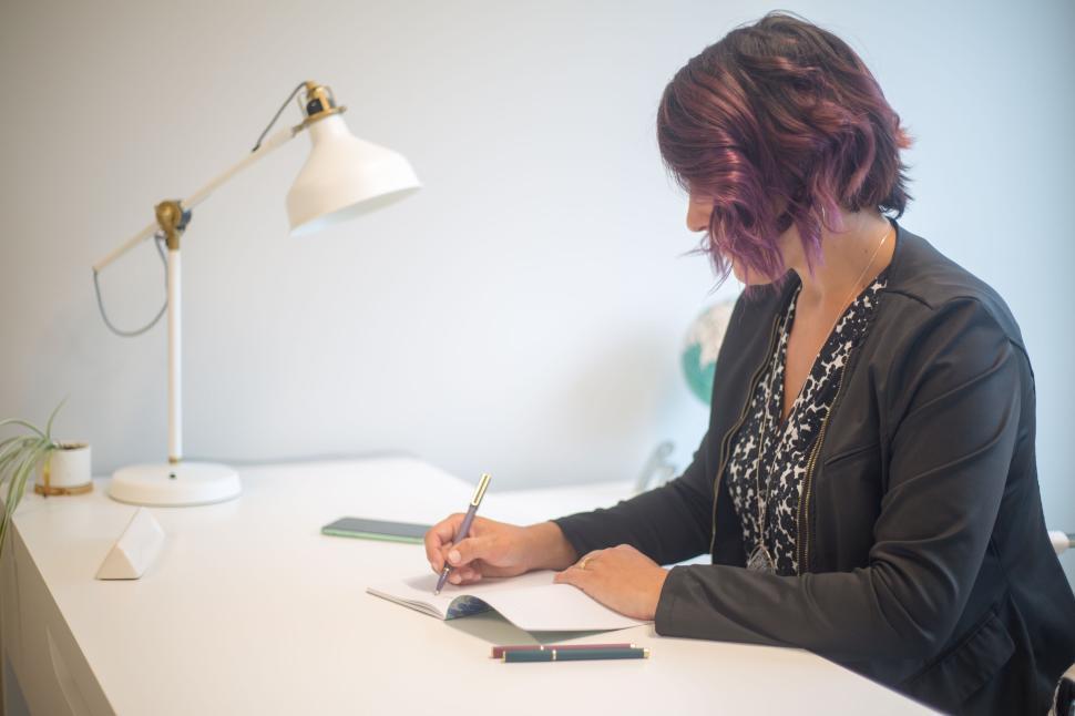 Free Stock Photo of Woman writing notes at her desk with modern office ...
