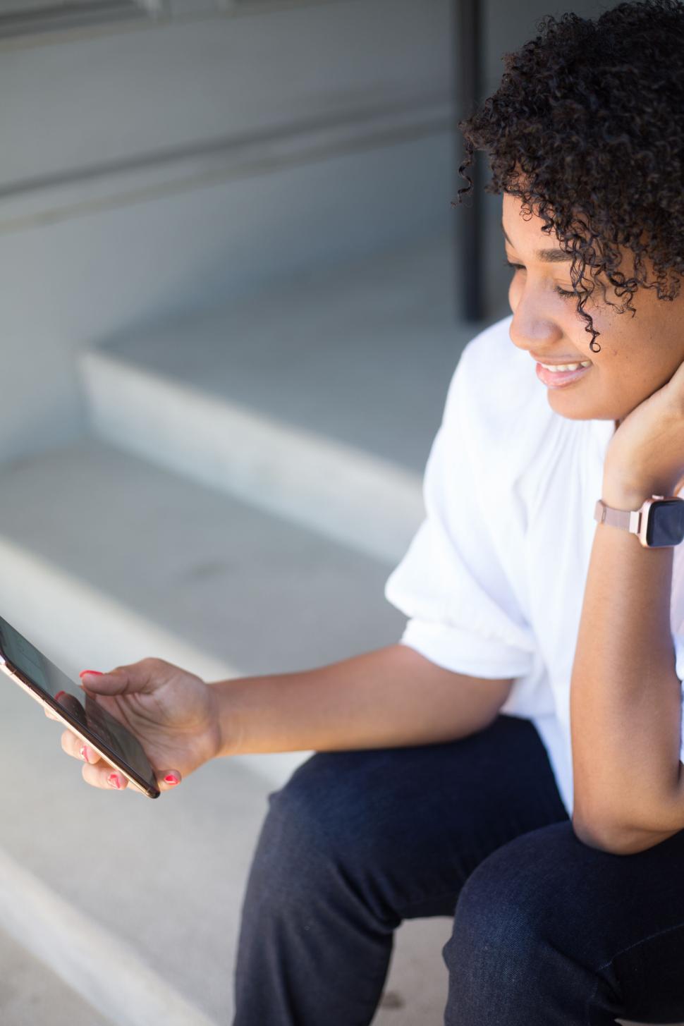 Free Stock Photo of Woman checking her phone while sitting on concrete ...