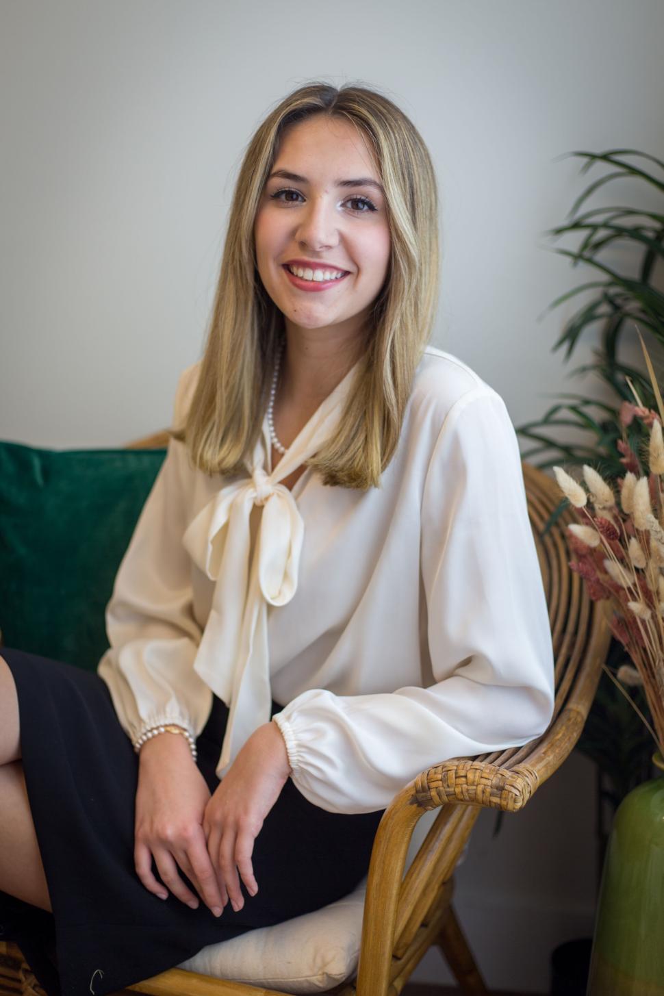 Free Stock Photo of Young professional woman seated with a smile in an ...
