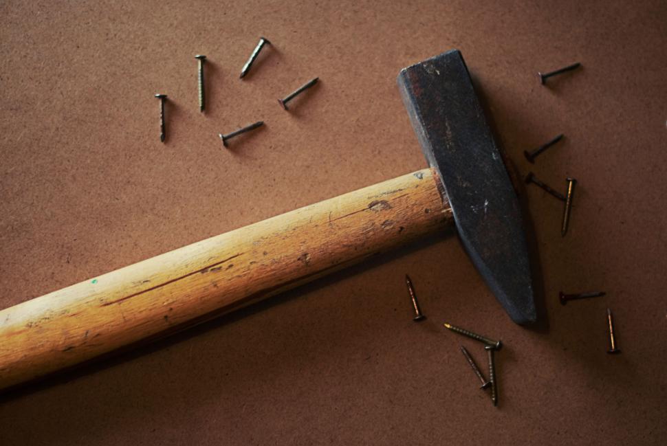 Free Stock Photo of Hammer with nails scattered on a brown wooden ...