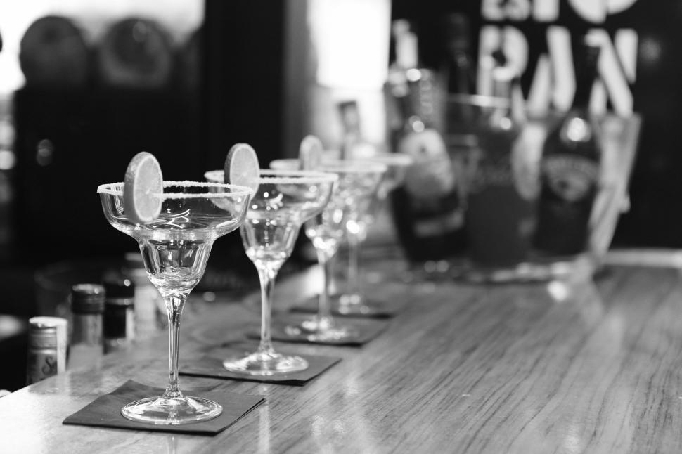 Free Stock Photo of Empty cocktail glasses lined up on a bar counter in ...