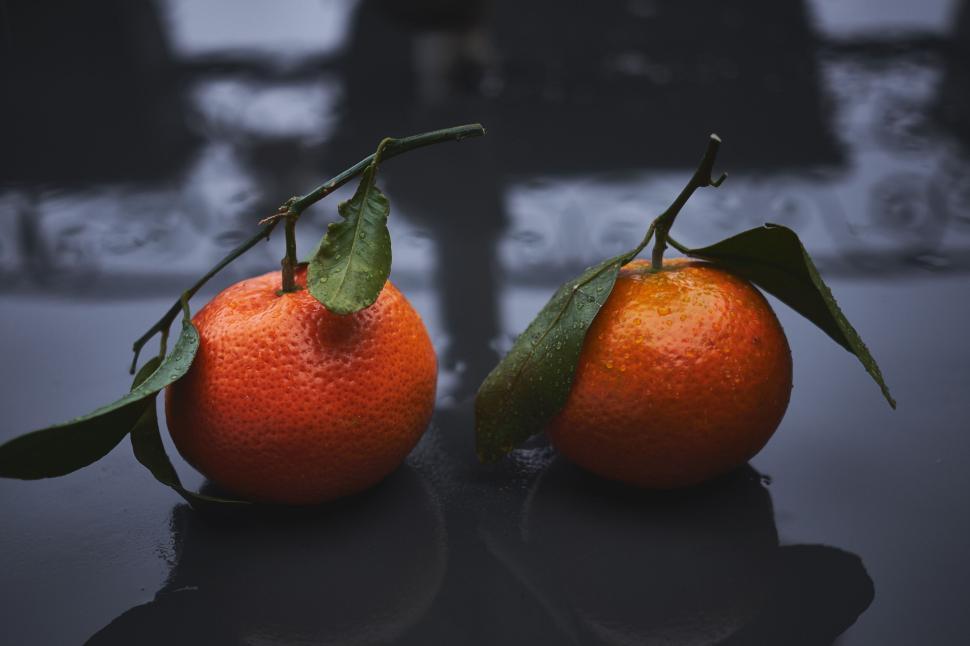 Free Stock Photo of Two fresh oranges with green leaves on a reflective ...
