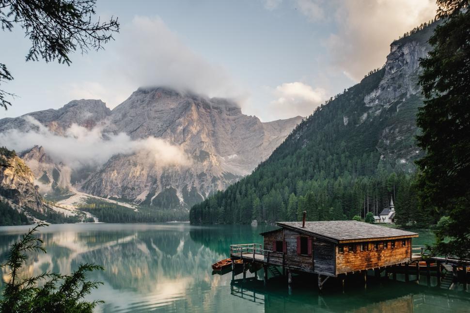 Free Stock Photo of Serene mountain lake with a cabin and mist-covered peaks view. | Download ...