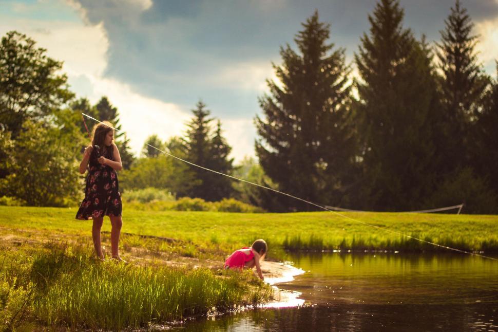 Free Stock Photo of Two children playing by a forest pond under a ...