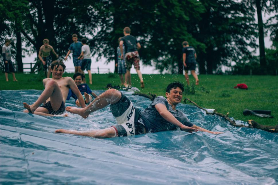 Free Stock Photo of People sliding on a wet outdoor tarp, all smiles ...