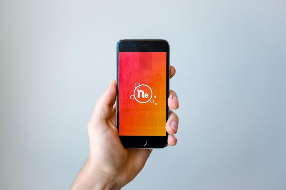 Free Stock Photo of Phone displaying a vibrant orange and red app ...