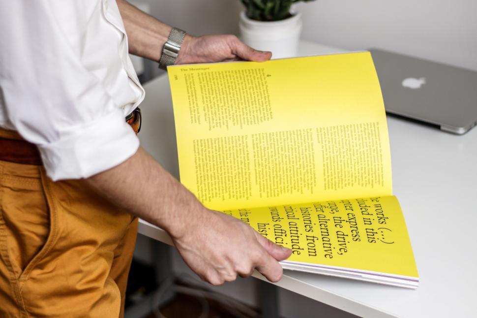 Free Stock Photo of Person holding open yellow book while standing ...