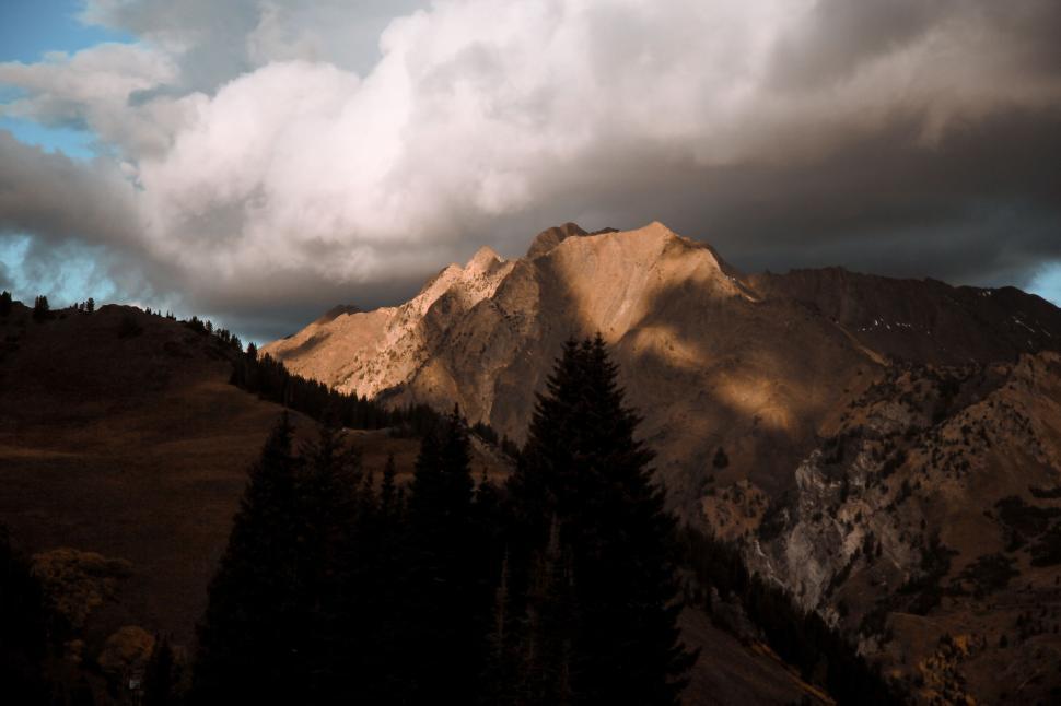 Free Stock Photo of Sunset over mountains with dark clouds overhead ...