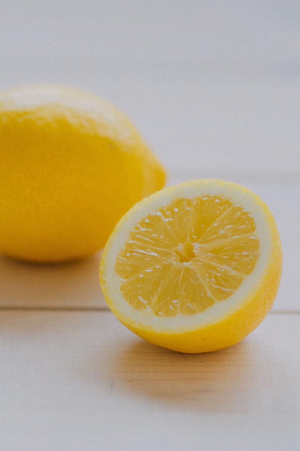 Free Stock Photo of Whole lemon and half-cut lemon on a white surface ...