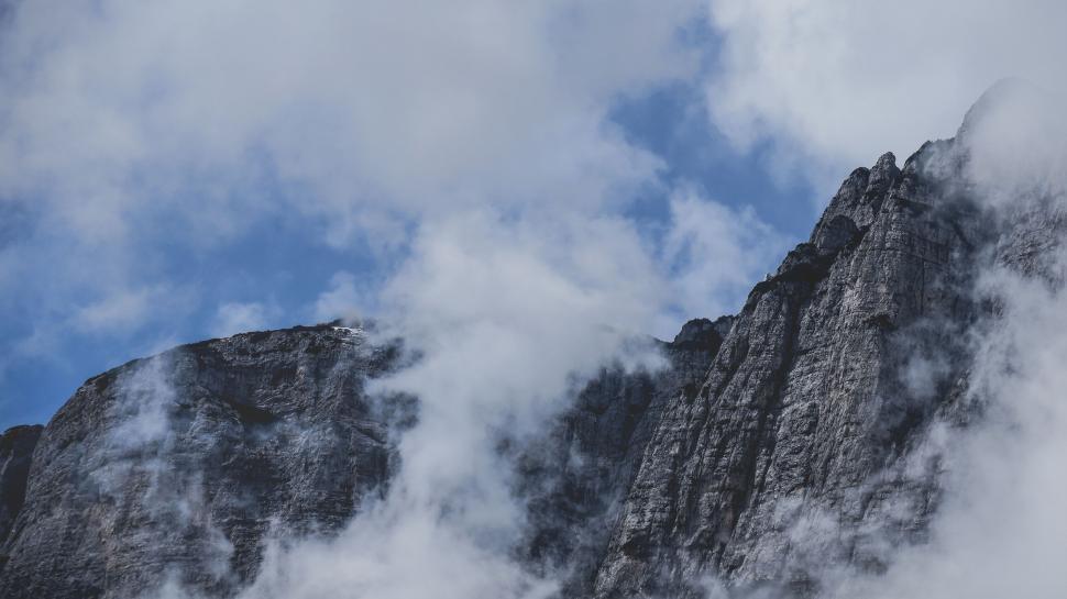 Free Stock Photo of Grey rocky mountain cliff with clouds swirling ...