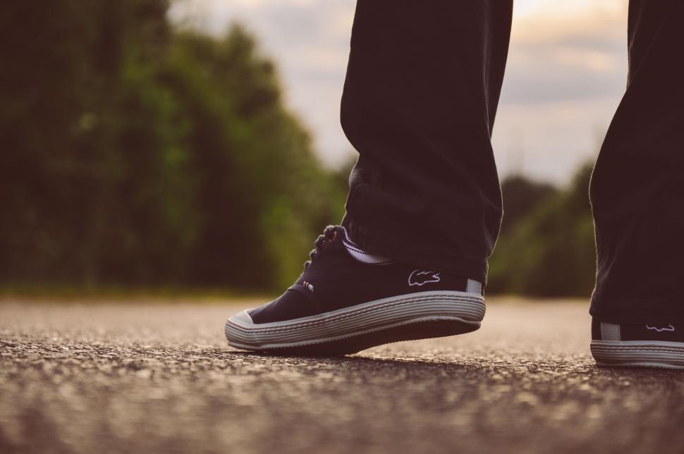 Free Stock Photo of Close-up of sneakers on pavement with nature ...