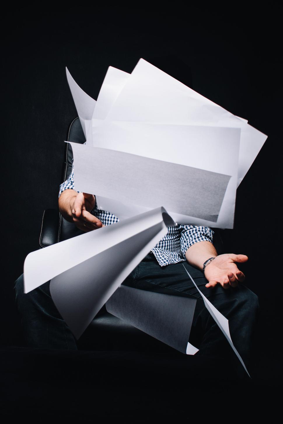 Free Stock Photo of Person sitting on chair with papers floating mid ...