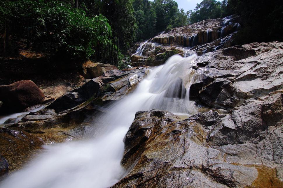 Free Stock Photo of A pristine rocky waterfall flows through dense ...