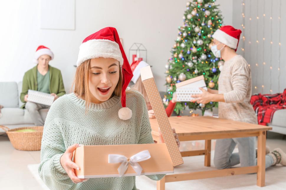 Free Stock Photo of Excited Woman Unwrapping Christmas Present Near ...