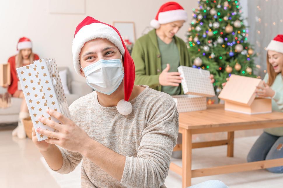 Free Stock Photo of Friends unwrapping gifts under decorated Christmas ...