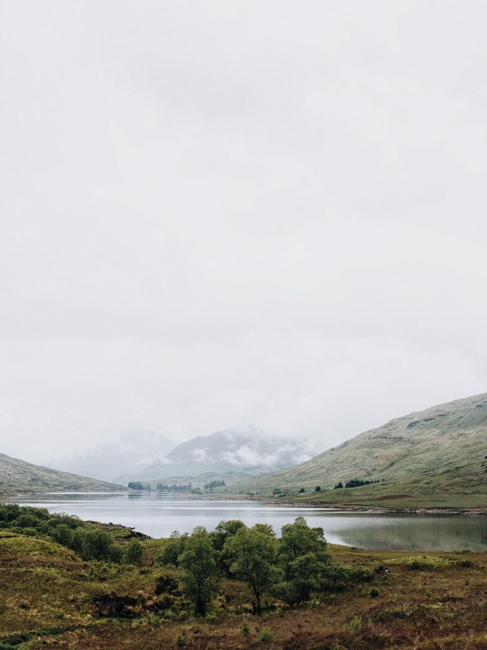 Free Stock Photo of Serene lake surrounded by misty hills and calm ...