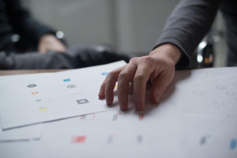Free Stock Photo of Person examining design sketches and logo drafts on ...