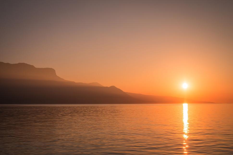 Free Stock Photo of Sunset over calm water with mountain silhouette ...