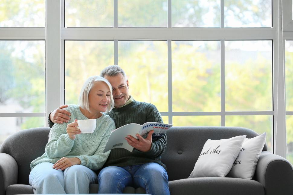 Free Stock Photo of Cozy scene of couple reading with cup in living ...