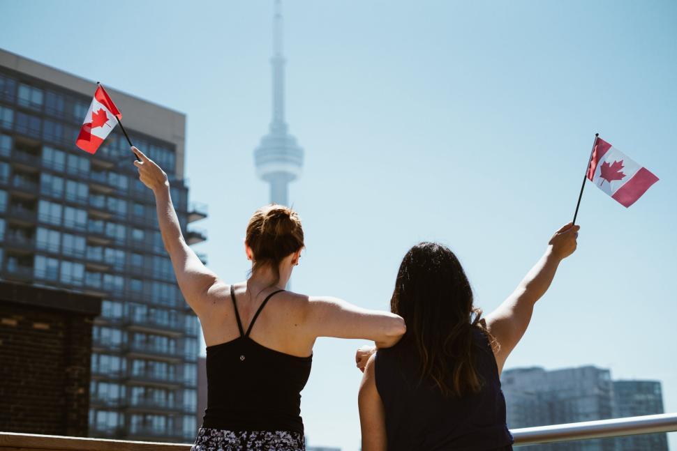 Free Stock Photo of Two people holding Canadian flags with CN Tower ...