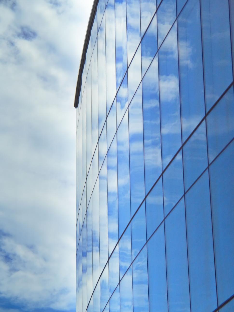 Free Stock Photo of Curved glass skyscraper reflecting blue sky and ...