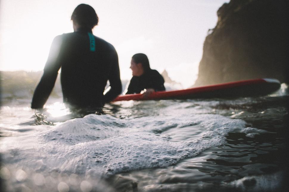 Free Stock Photo of Two people in wetsuits with surfboard preparing to ...