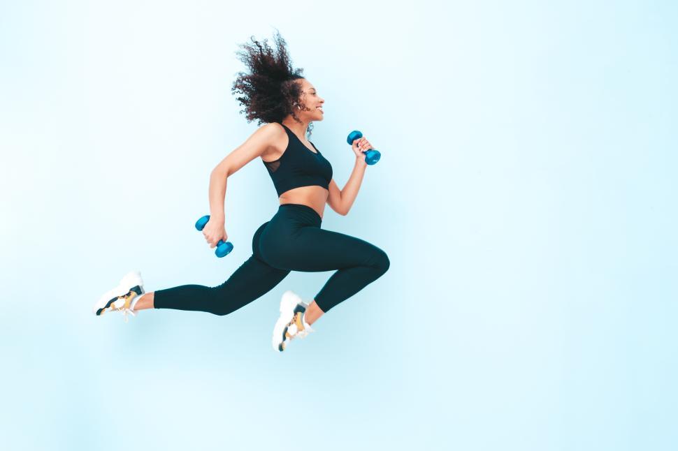 Free Stock Photo of Dynamic leap with dumbbells in athletic outfit ...