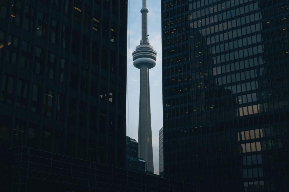 Free Stock Photo of CN Tower framed by dark tall buildings in distance ...
