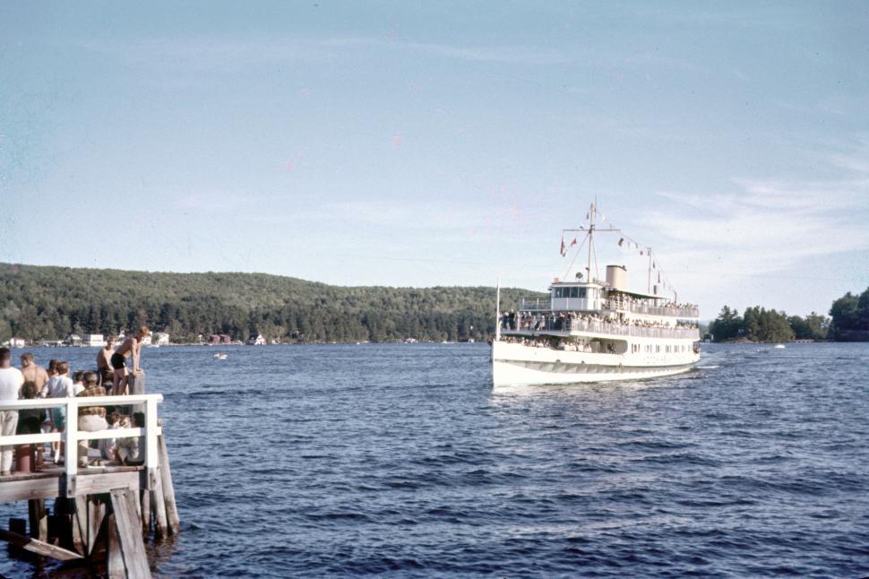 Free Stock Photo of Crowded boat approaches a pier on a calm blue lake ...