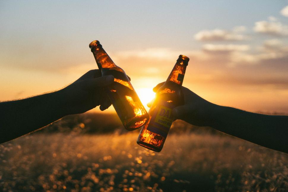 Free Stock Photo of Two beer bottles clinking against sunset background ...