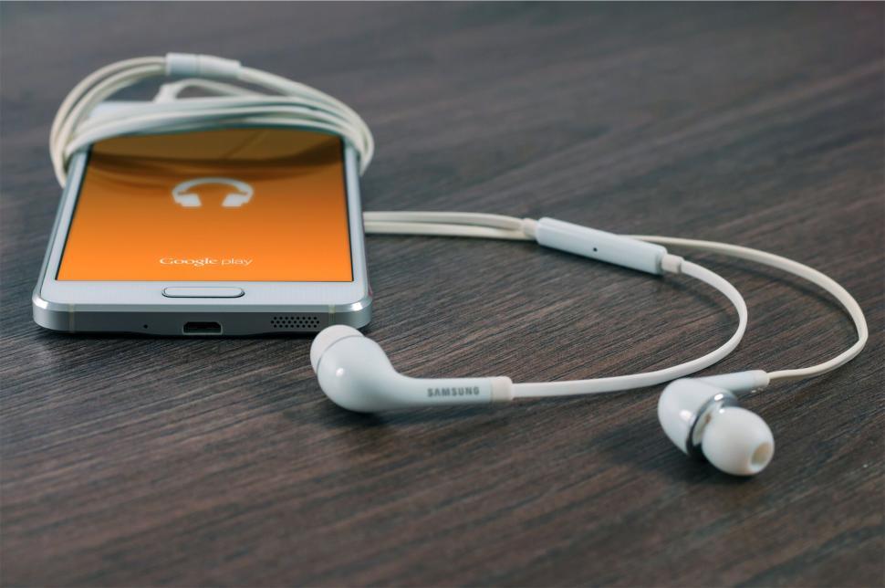 Free Stock Photo of Earphones wrapped around smartphone with music app ...