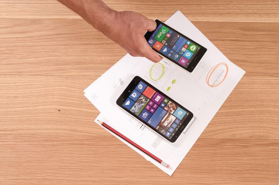 Free Stock Photo of Hand holding dual smartphones over technical ...