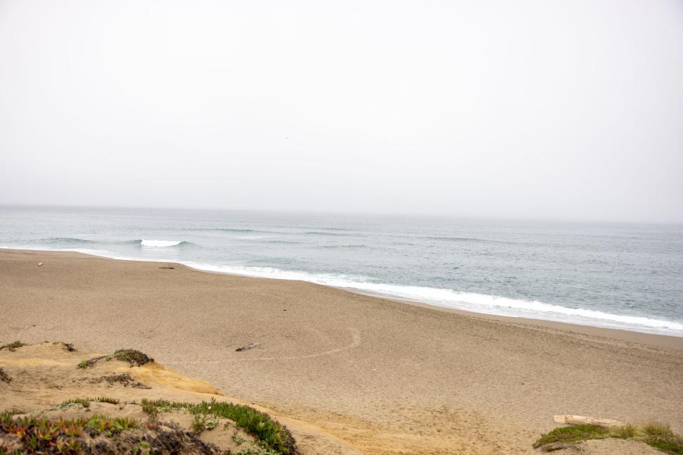 Free Stock Photo of Empty beach with gentle waves under a overcast sky ...