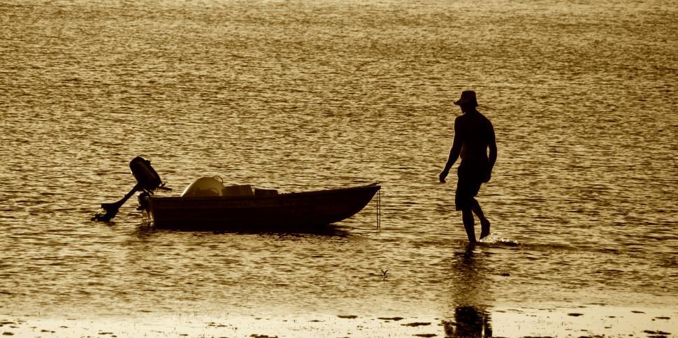 Free Stock Photo of A man wading with a small boat during golden hour ...