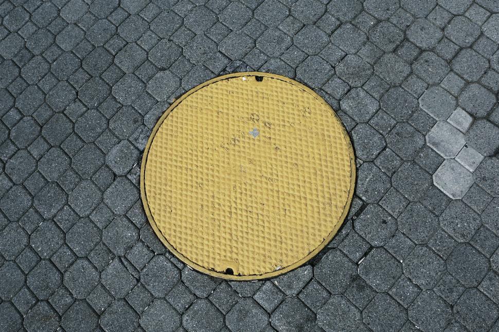 Free Stock Photo of Circular yellow manhole cover on textured pavement ...