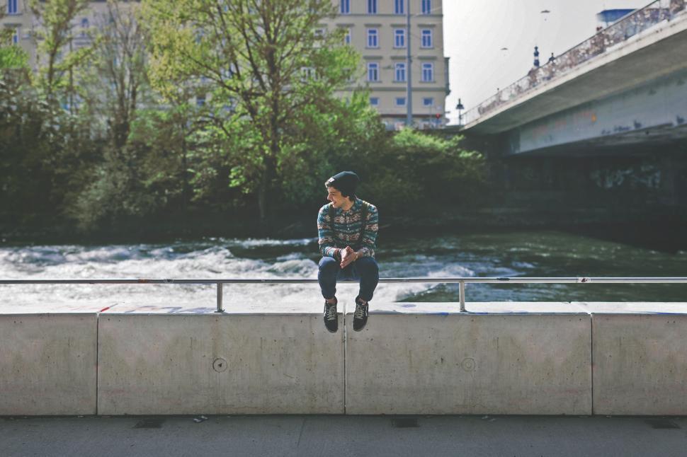 Free Stock Photo of Man Sitting on Ledge Looking at River | Download ...
