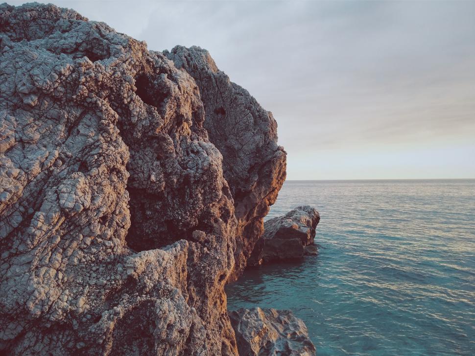 Free Stock Photo of Massive Rock Outcropping Extending Into Ocean ...