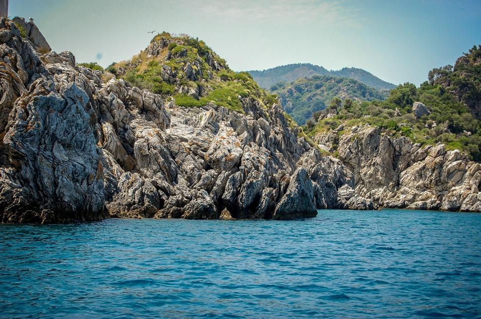 Free Stock Photo of A Large Body of Water Surrounded by Rocks ...