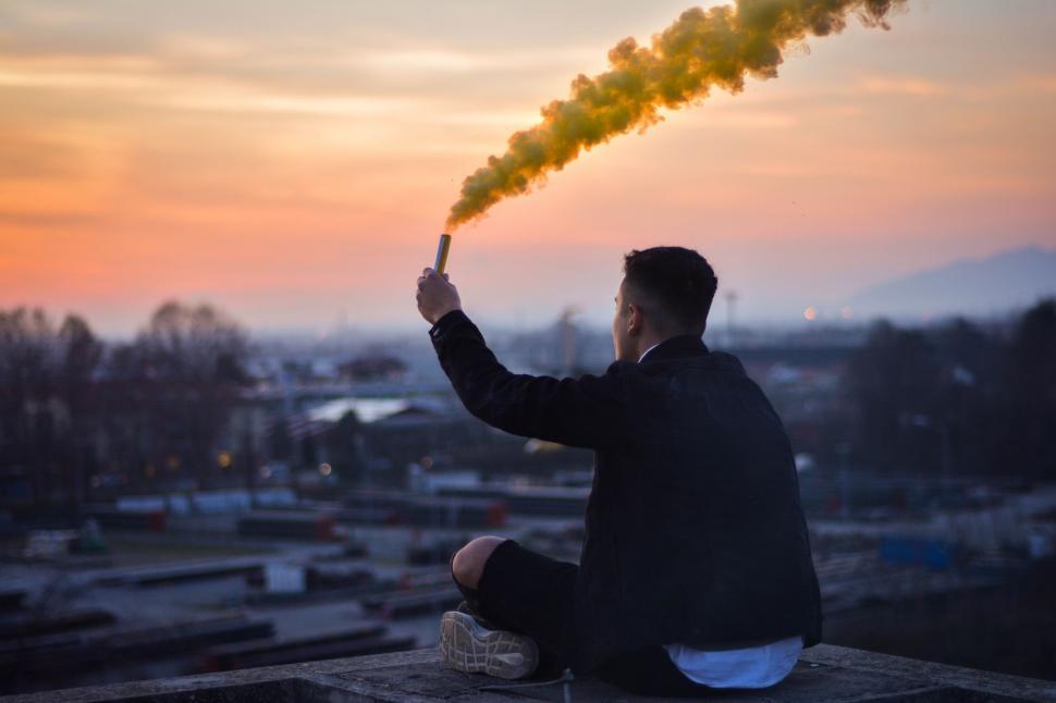 Free Stock Photo of Man Sitting on Roof Holding Yellow Smokestack ...