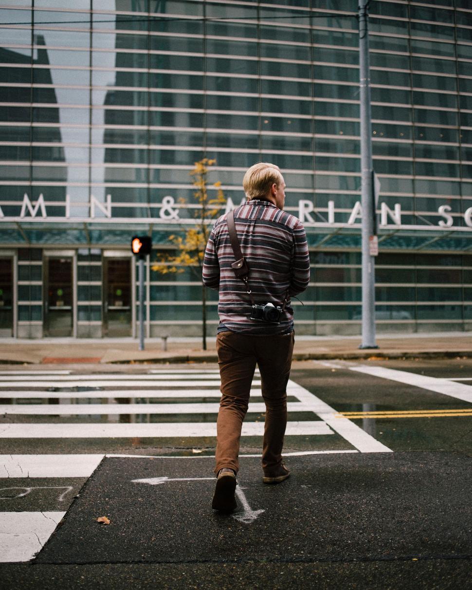 Free Stock Photo of Man Walking Across Street Next to Tall Building ...